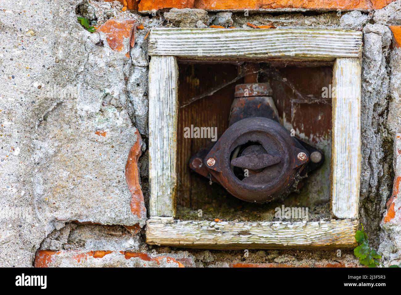Old electrical on-off switch on the outside wall of the building ...
