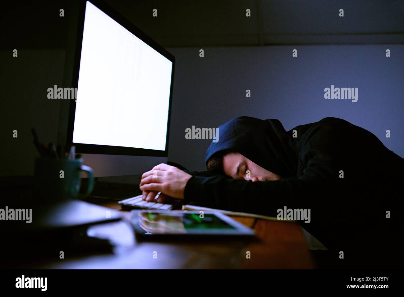 Falling asleep by the light of his monitor. Shot of an exhausted ...