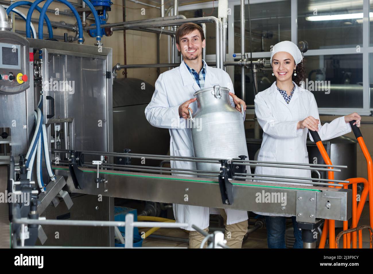 Workers showing dairy production process Stock Photo - Alamy