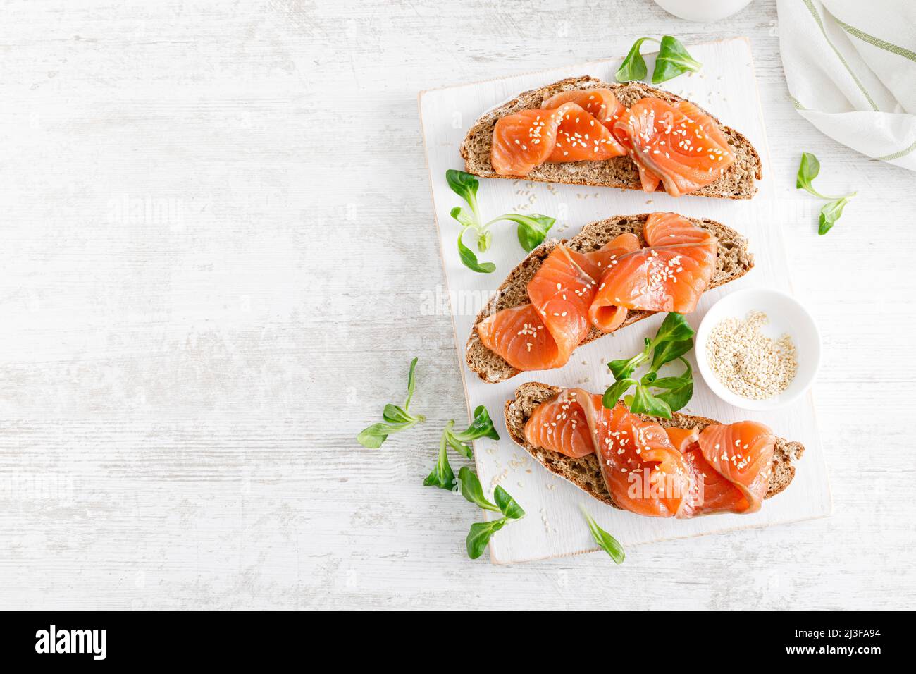 Whole grain rye bread open sandwiches with salted salmon on a white ...