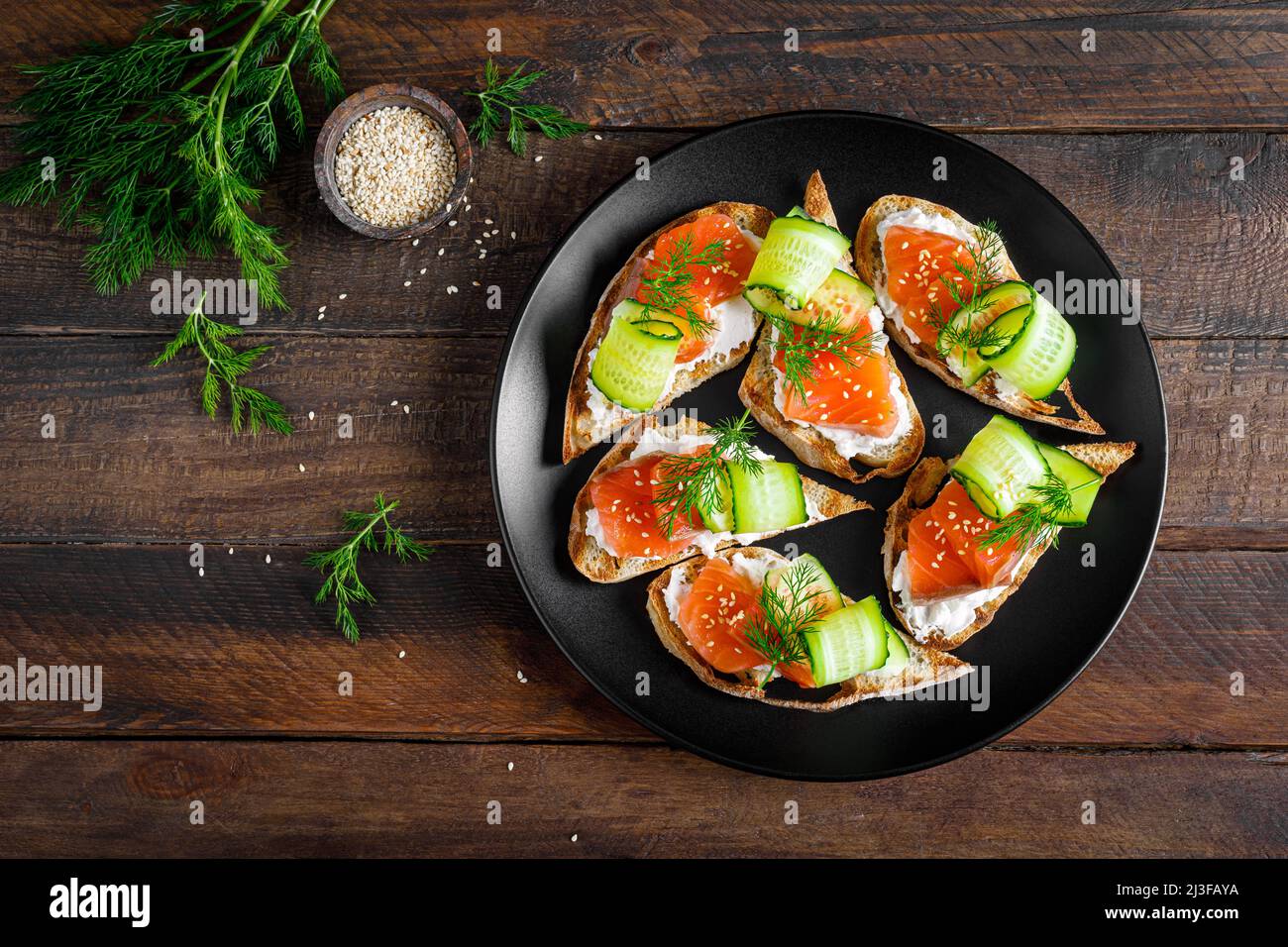 Toasts with salted salmon fish, ricotta cheese, fresh cucumber and ...