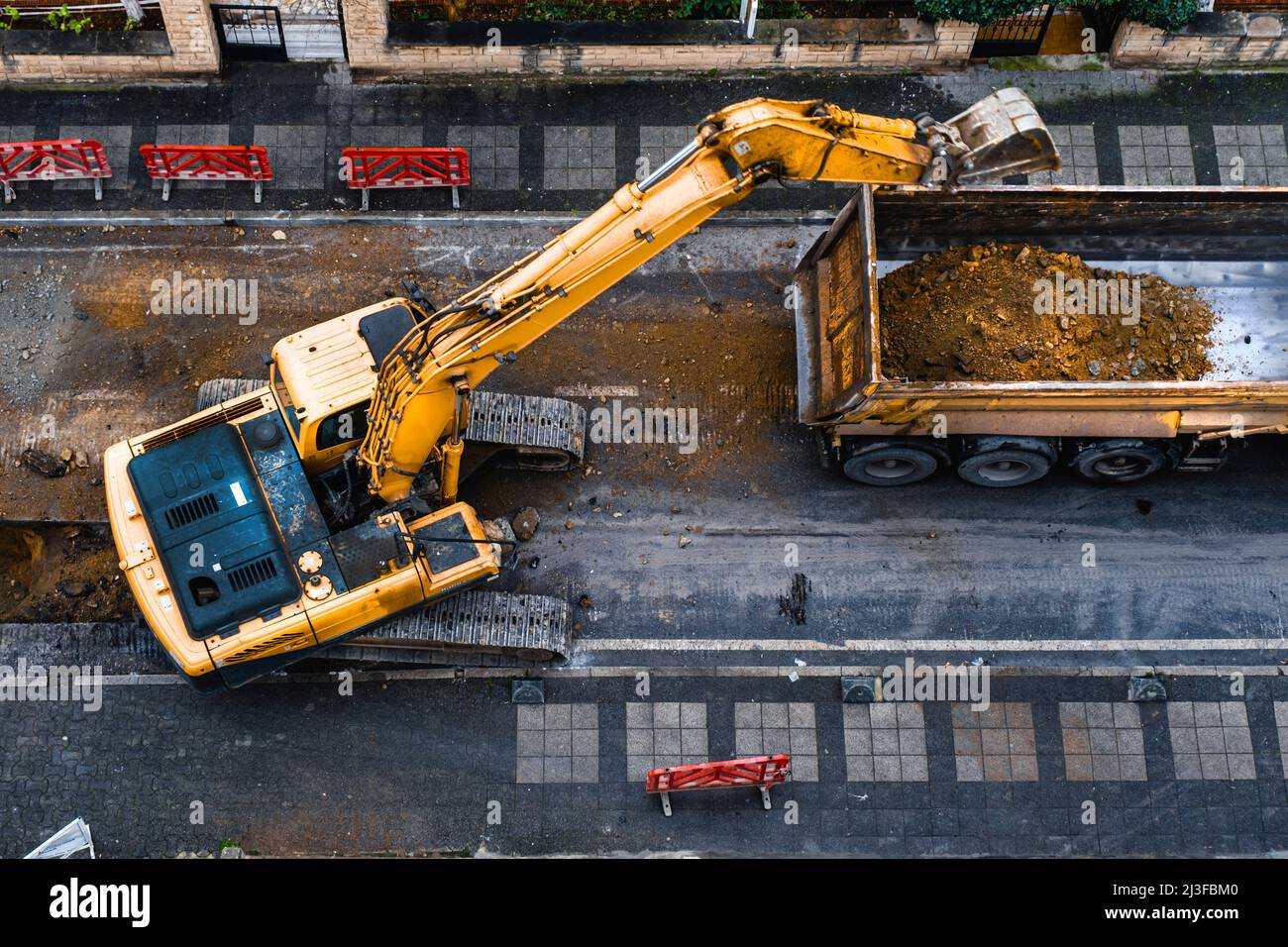 Construction equipment excavates a city street to improve the ...