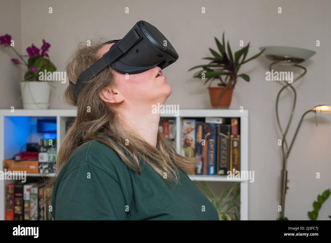 A girl in VR glasses in a room. Side view. A woman traveling in a meta ...