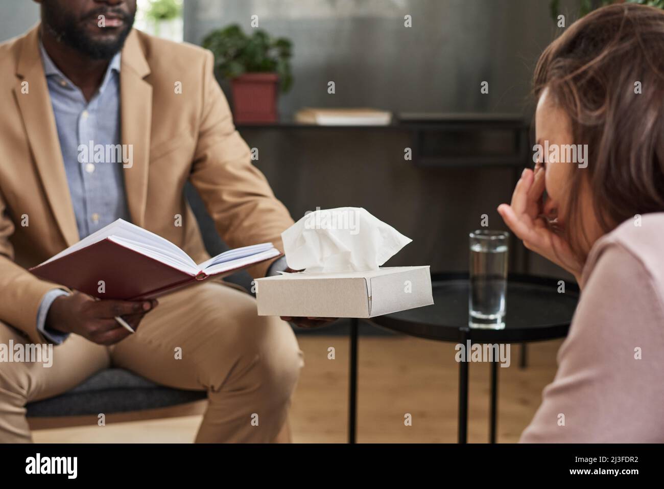 Crying despondent young woman wiping tears while talking to ...
