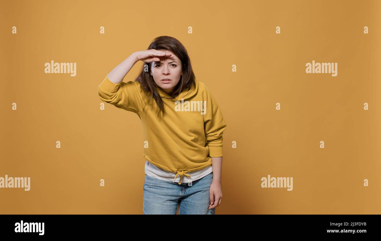 Curious woman looking into the distance far away searching for ...