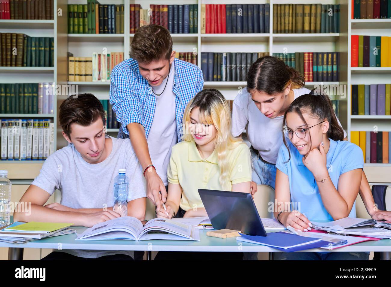 Group of teenage students study in library class Stock Photo - Alamy