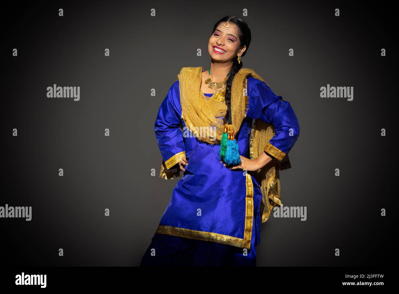 Portrait of a happy Sikh woman posing in front of camera with hands on ...