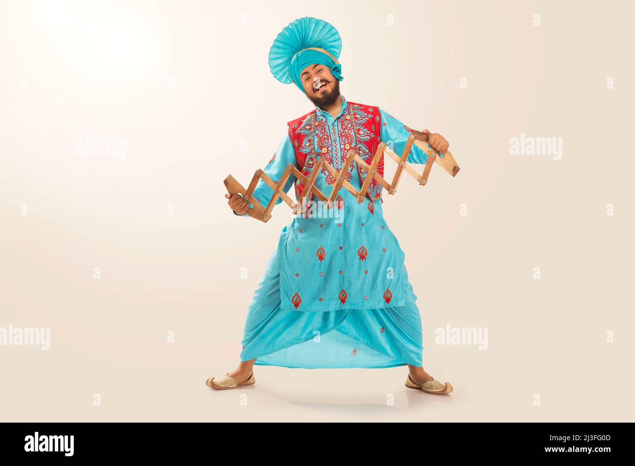 Portrait of Sikh Man performing bhangra with sapp during Baisakhi ...
