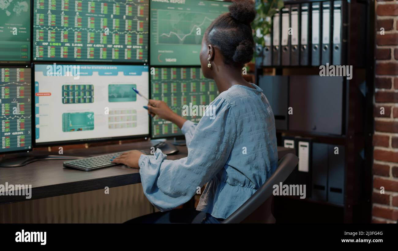 African american analyst trading stock market exchange and using multi ...