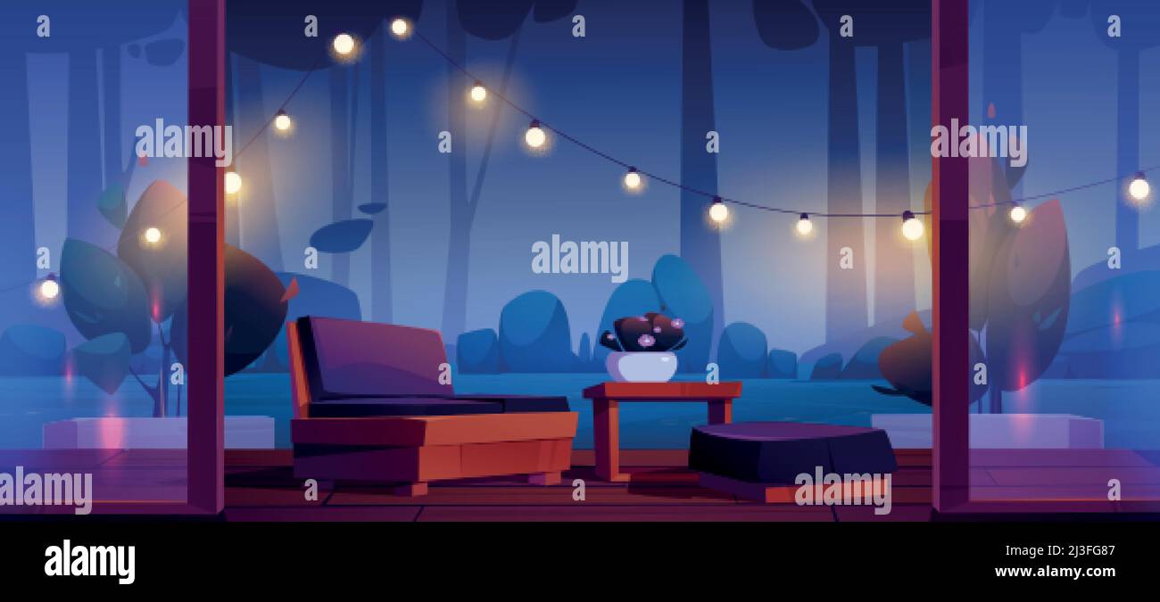 House terrace with table, couch, string lights and view to dark garden ...