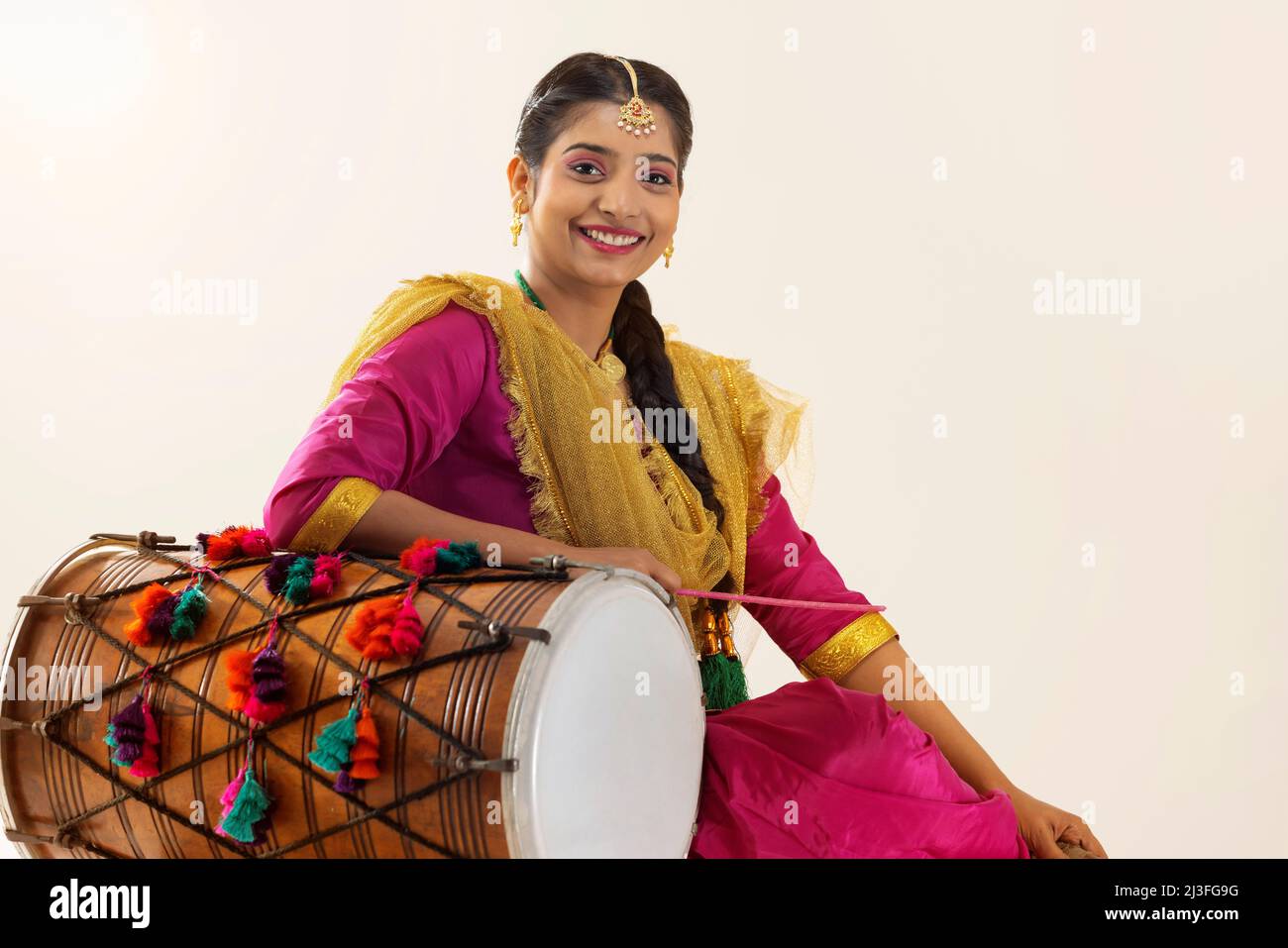 Portrait of Sikh woman in traditional outfit sitting with drum on the ...
