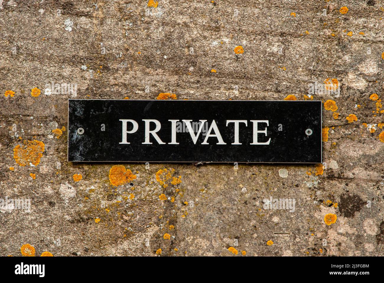 Old mossy stone wall with private plate closeup Stock Photo - Alamy
