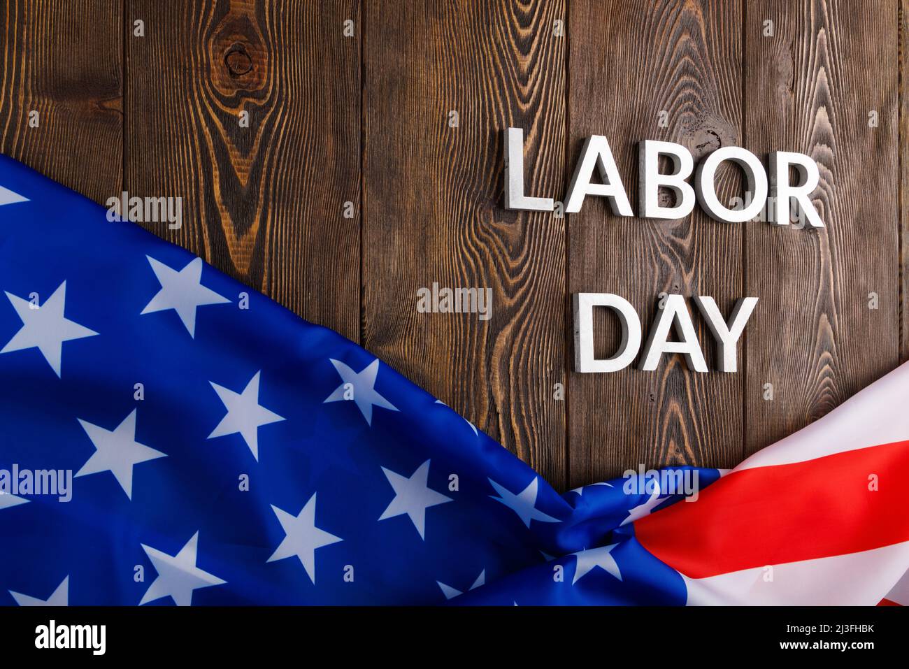 words labor day laid with silver metal letters on wooden surface with ...
