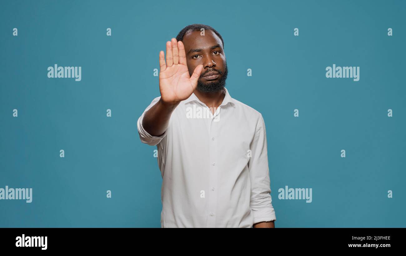 Negative person doing stop symbol with palm in studio, expressing ...