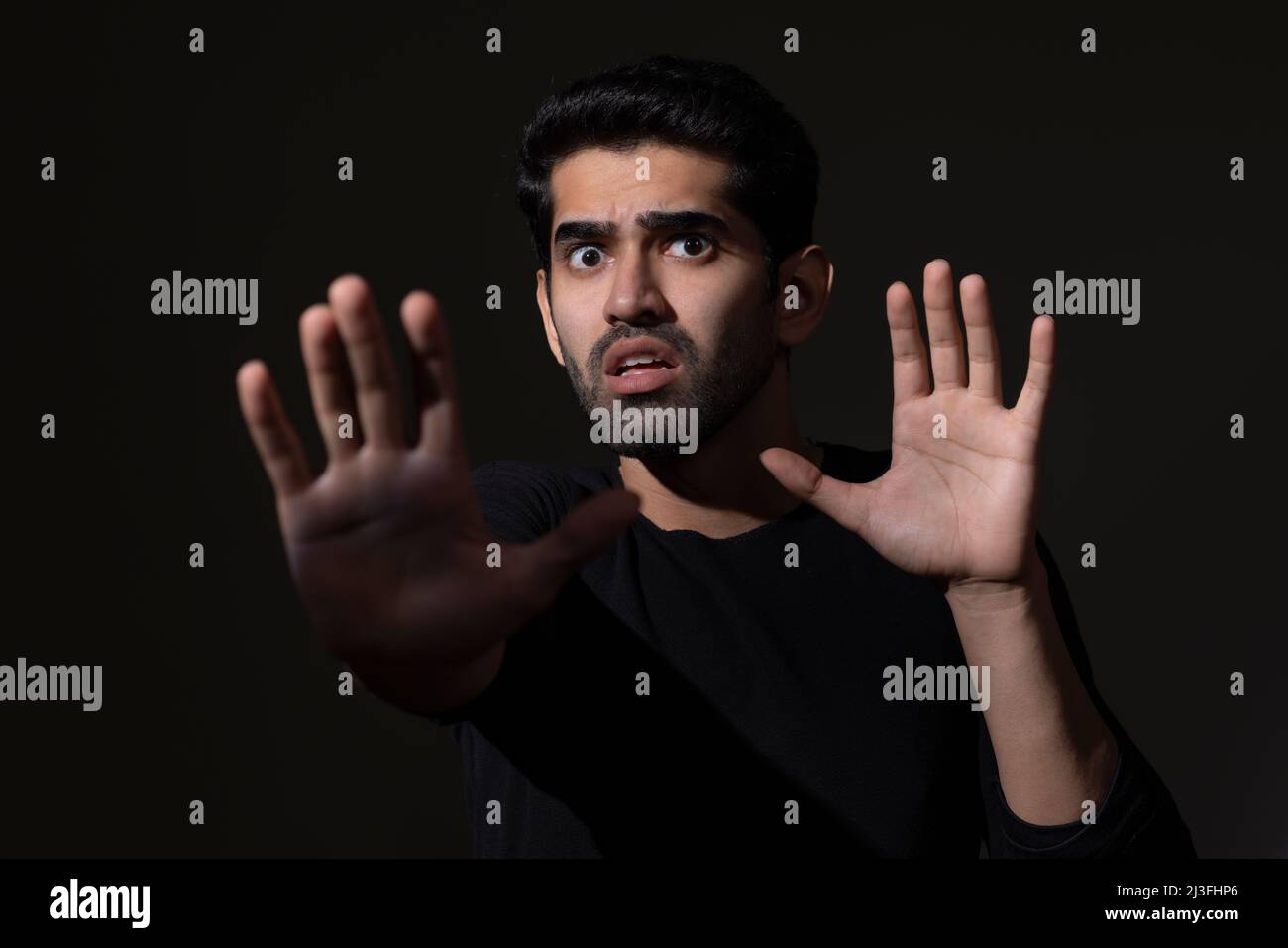 Portrait of a scared young man gesturing with his hands Stock Photo - Alamy