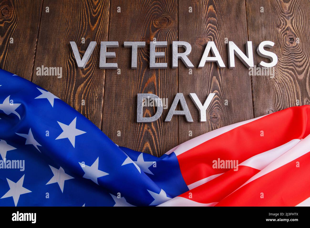 the words veterans day laid with silver metal letters on wooden board ...