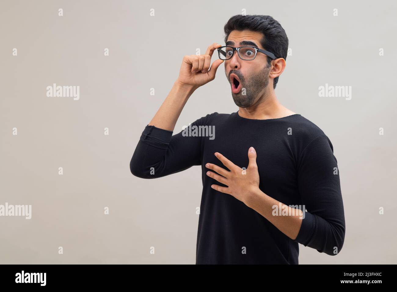 Portrait of a stunned young man looking elsewhere with open mouth, wide ...