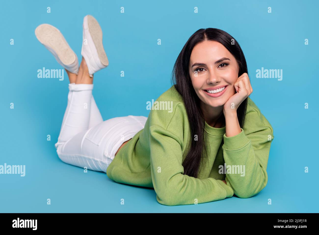 Full body portrait of satisfied friendly person lay floor arm cheekbone ...