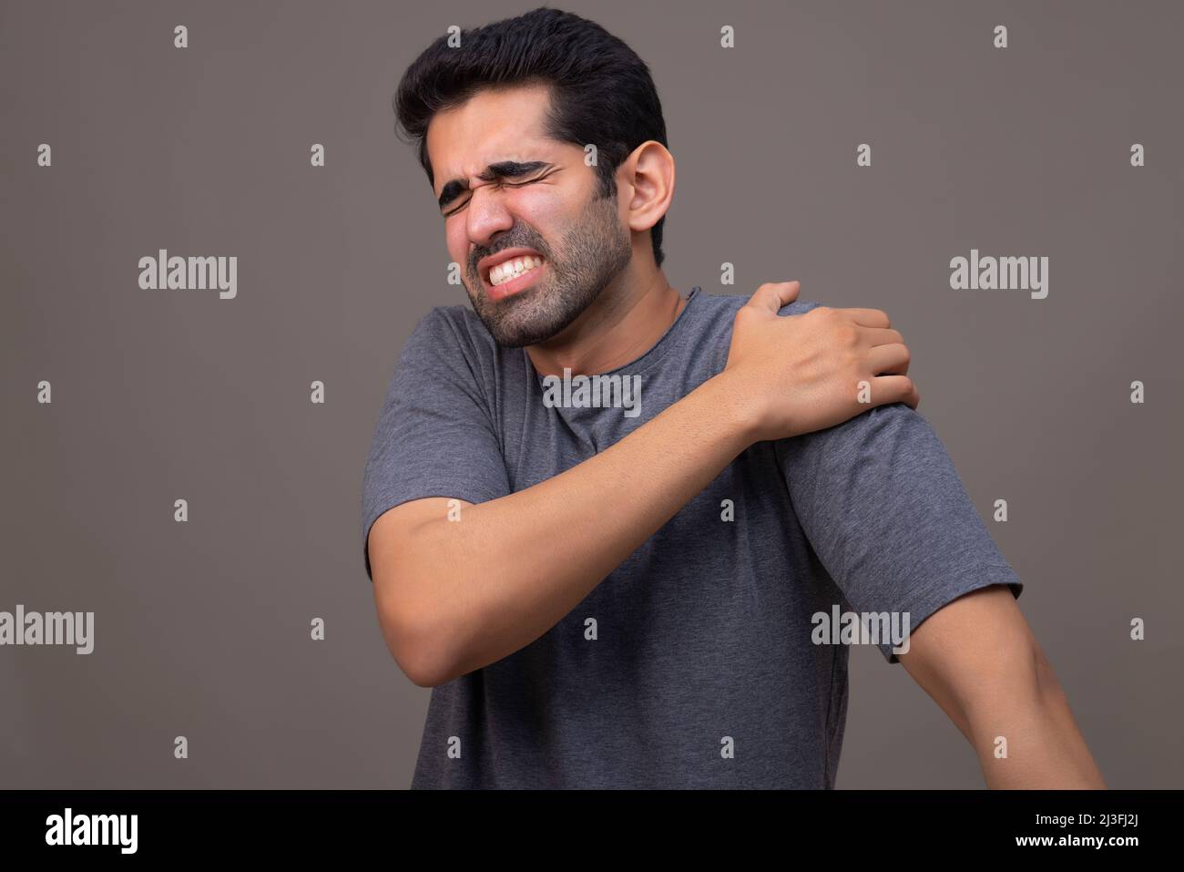 Portrait of a young man suffering from shoulder pain Stock Photo - Alamy
