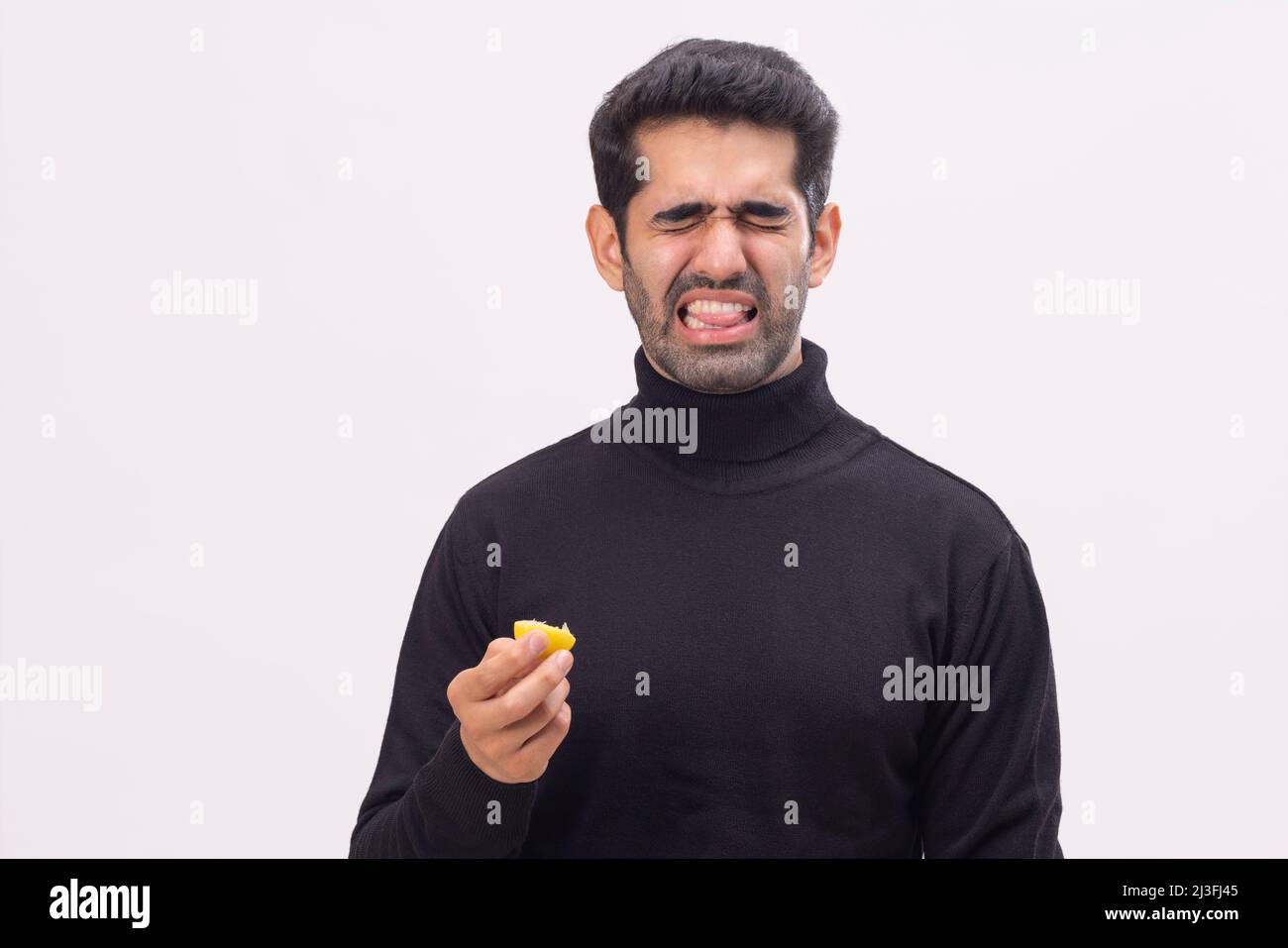 Expression of a young man after sucking sour lemon Stock Photo - Alamy