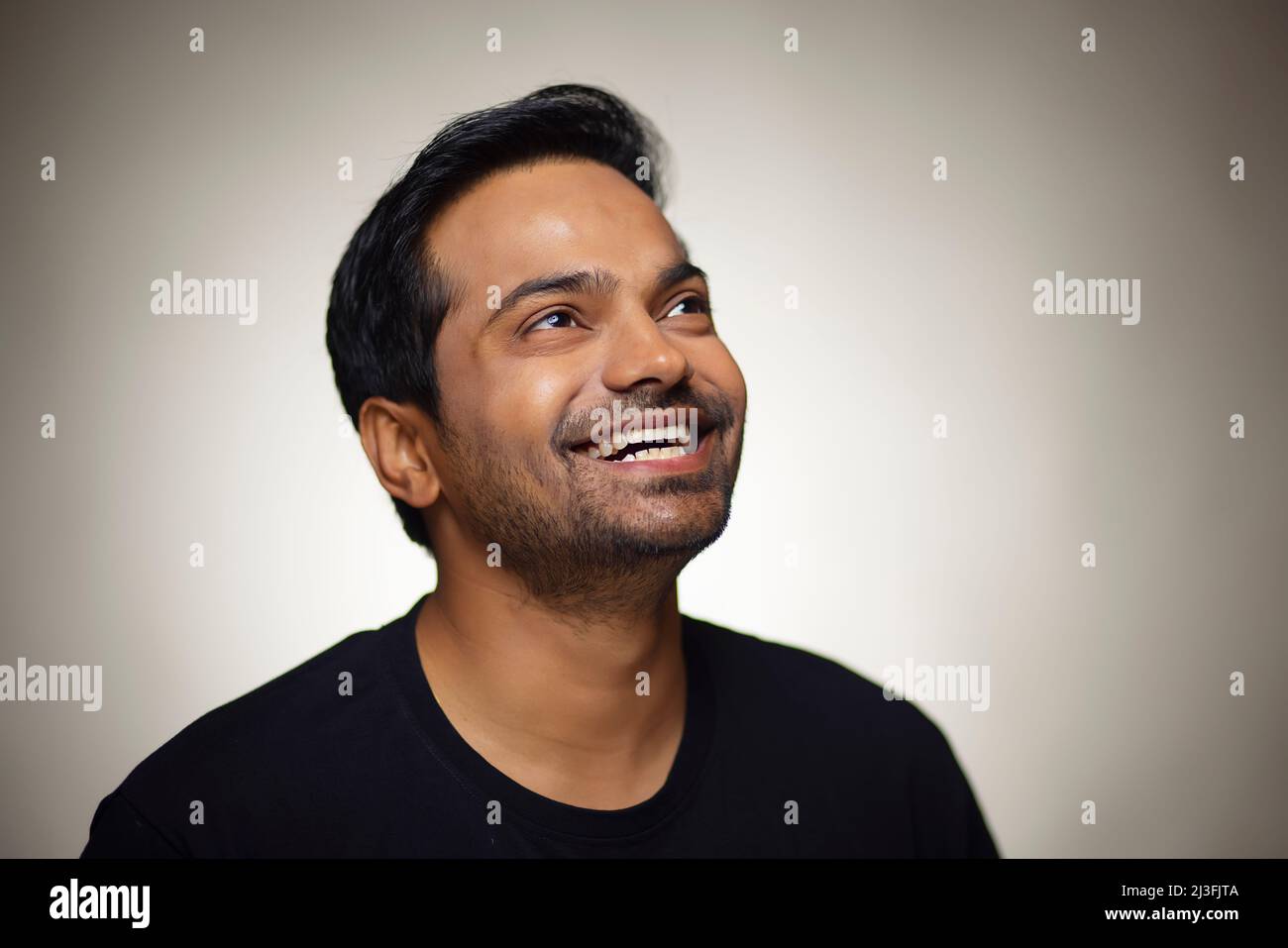 Portrait of happy young man looking above with smile Stock Photo - Alamy