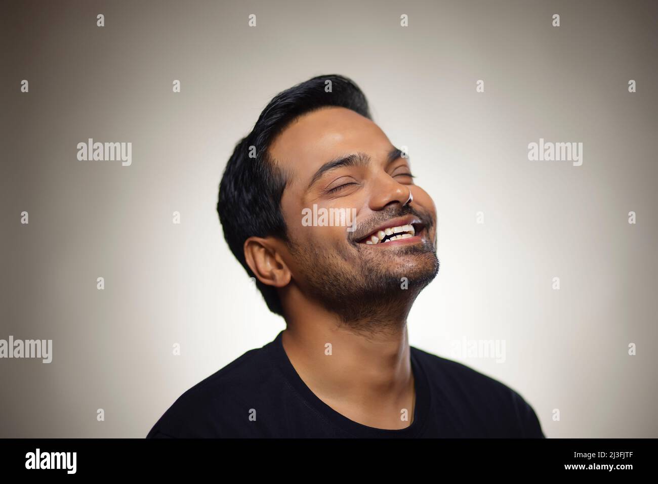Portrait of a happy young man smiling with his eyes closed Stock Photo ...