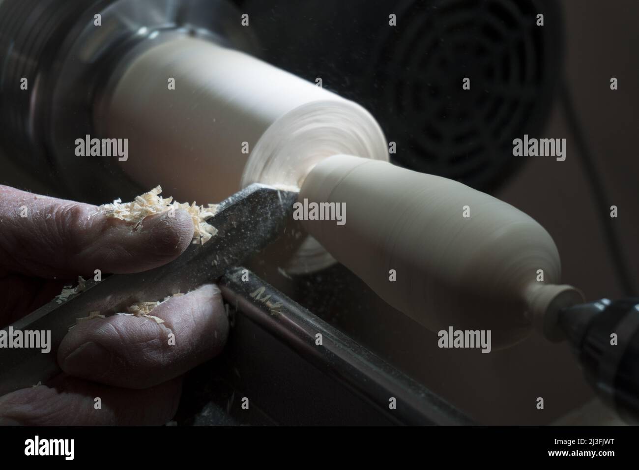 Close up of fast spinning wooden workpiece during wood turning with ...