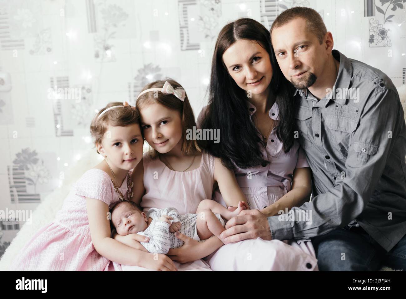 happy family and a newborn baby in the hands of his older sister ...