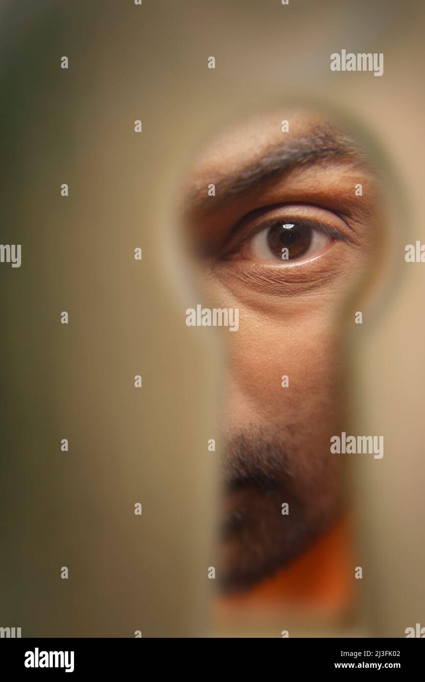 Close-up portrait of a human face looking through keyhole Stock Photo ...