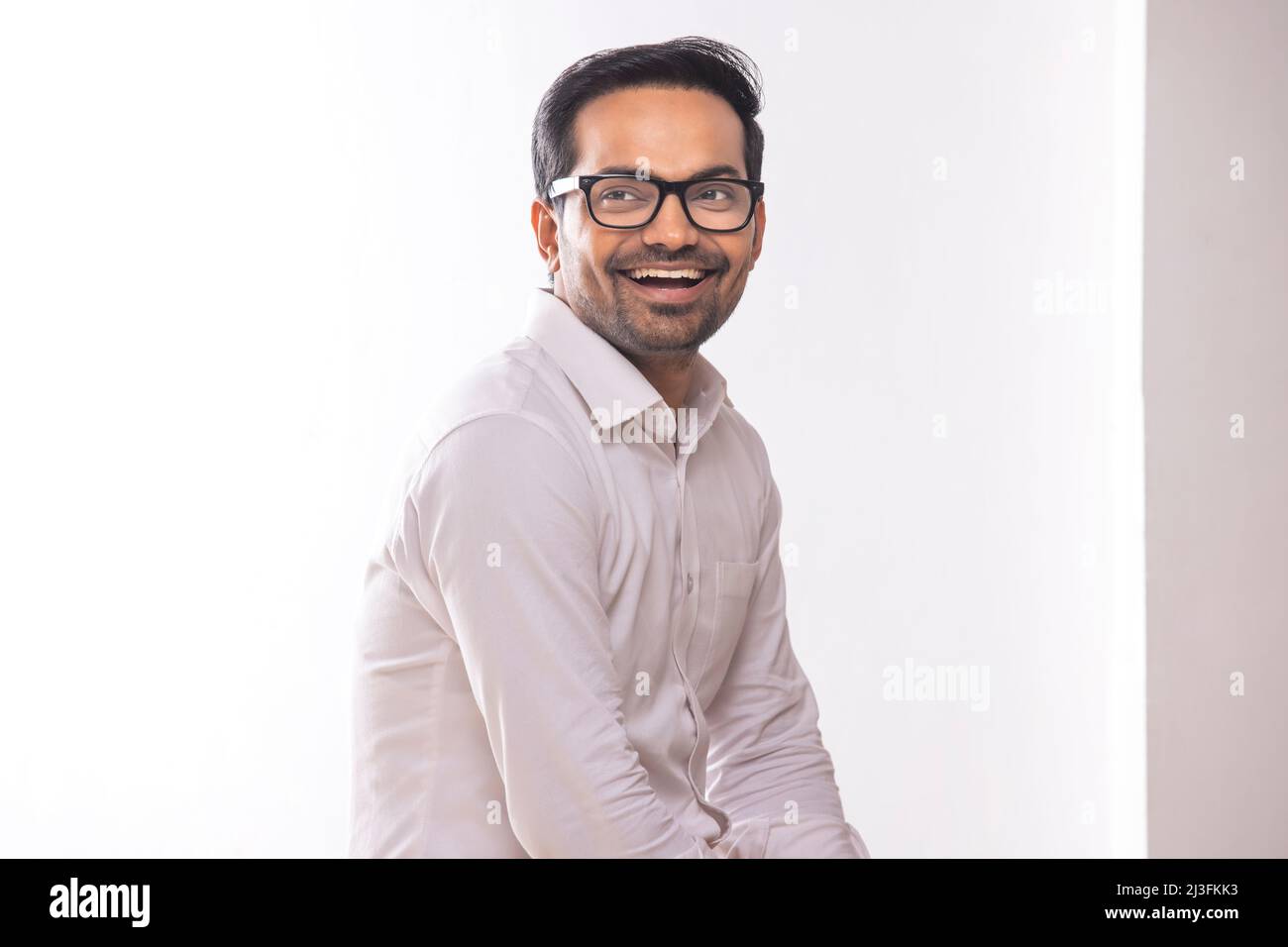 Portrait of an young employee in white shirt looking elsewhere with ...