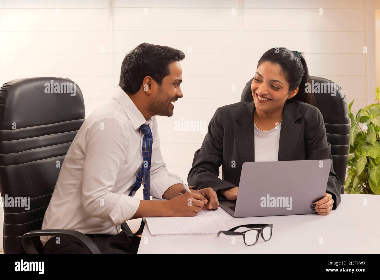 Happy business couple talking each other while working in office Stock ...