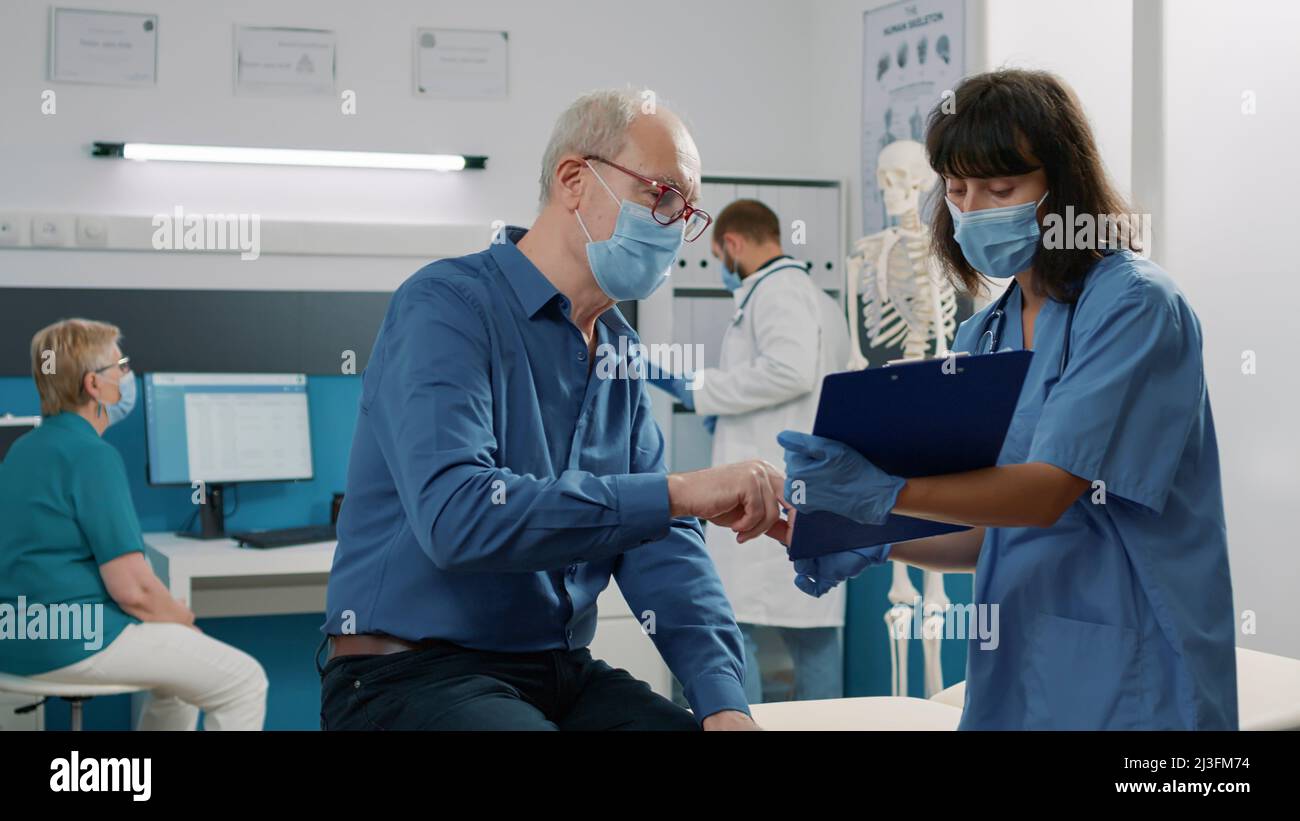 Senior patient signing checkup papers to receive treatment after ...