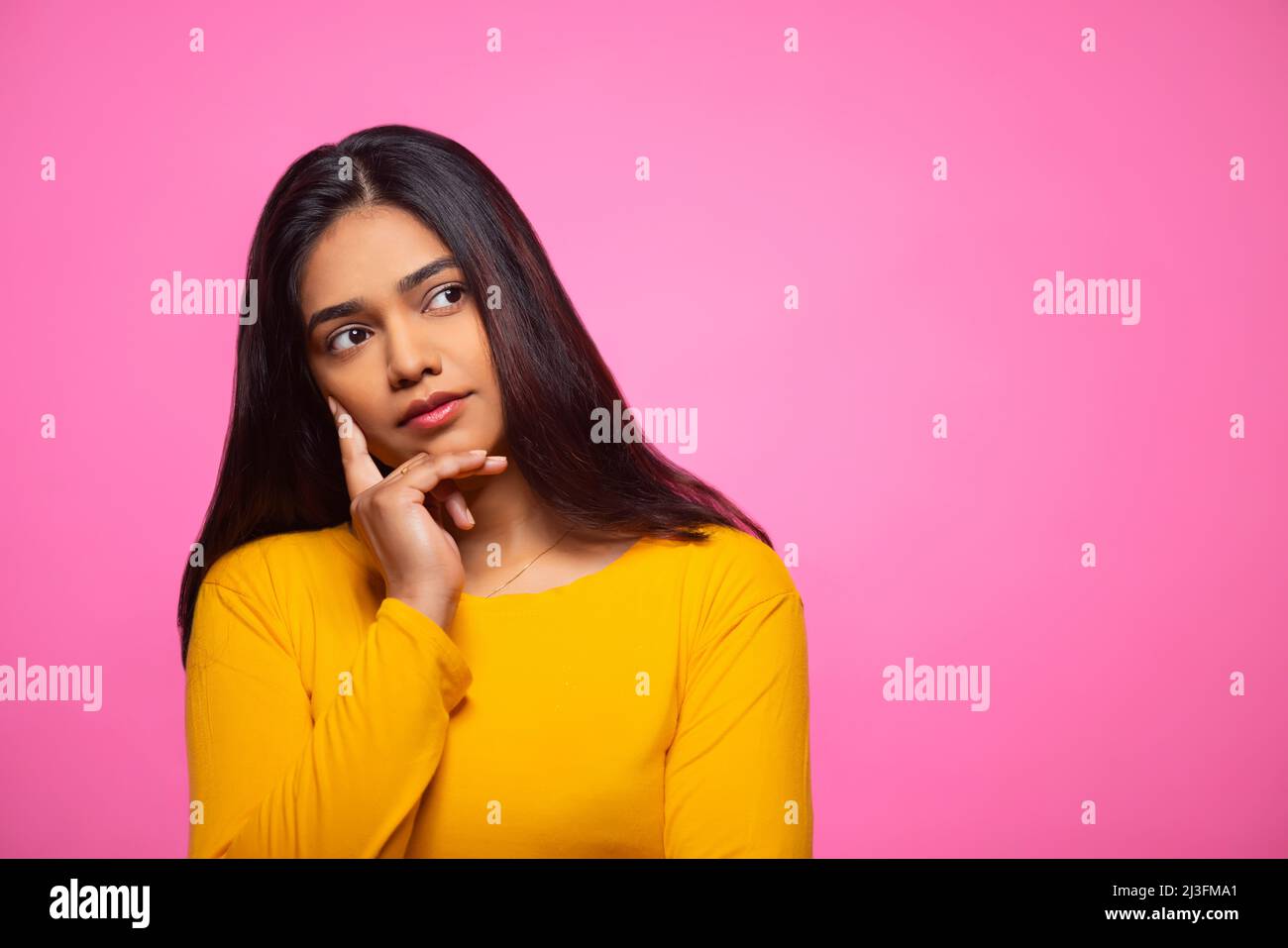 Portrait of a young woman looking elsewhere with hand on cheek Stock ...