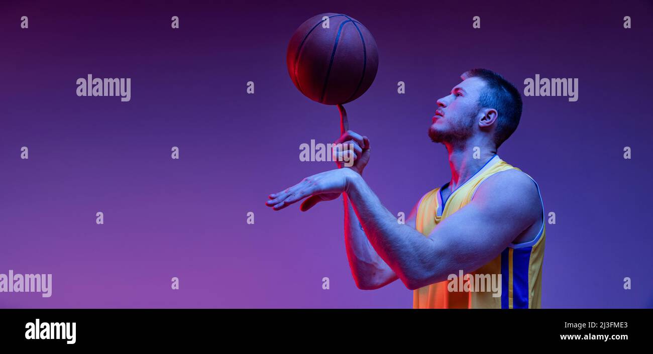 Spin. Studio shot of muscled man, basketball player training with ball ...