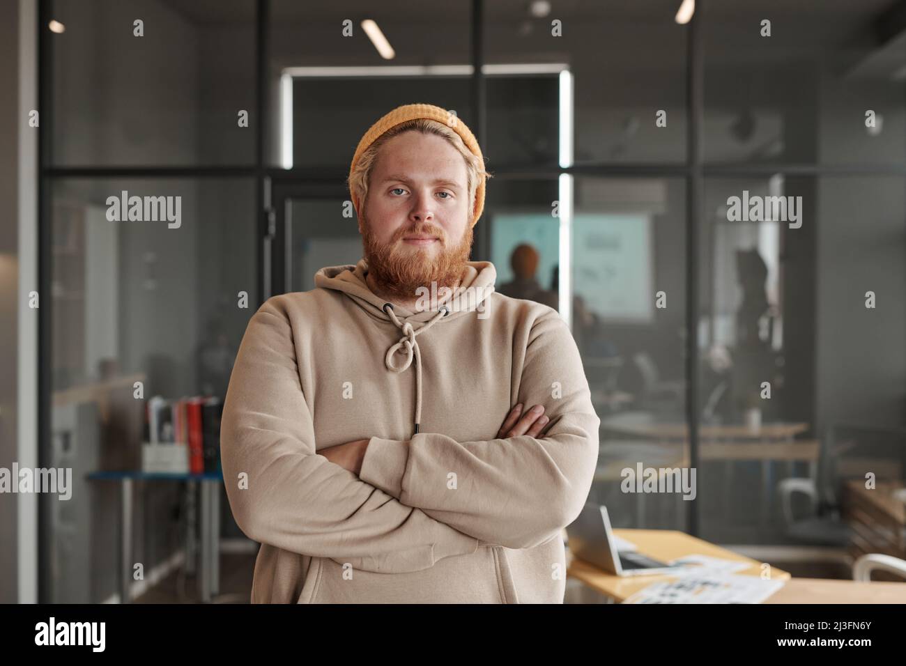 Portrait of young Caucasian app developer with beard standing with ...