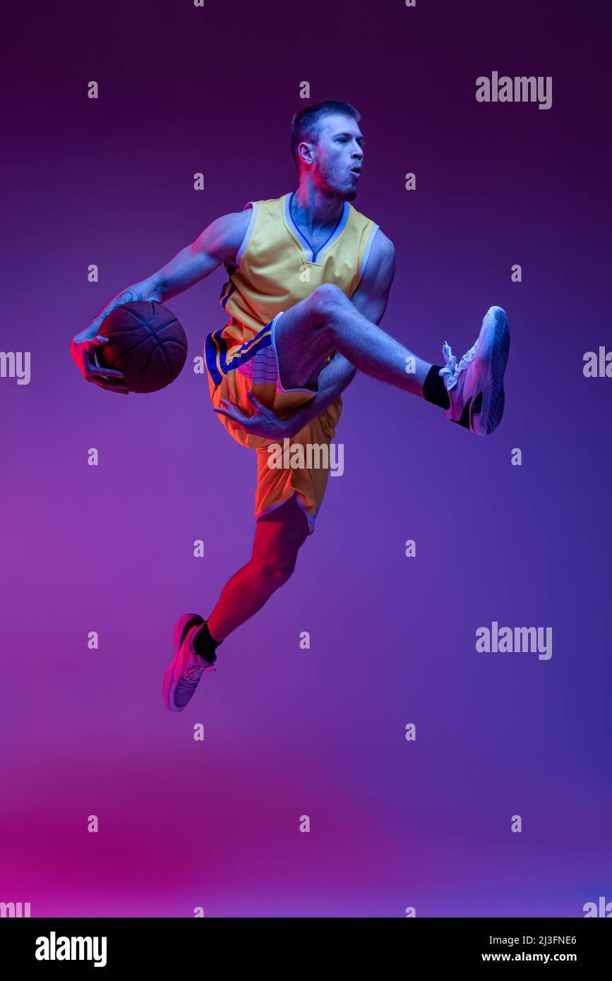 Studio shot of muscled man, basketball player training with ball ...