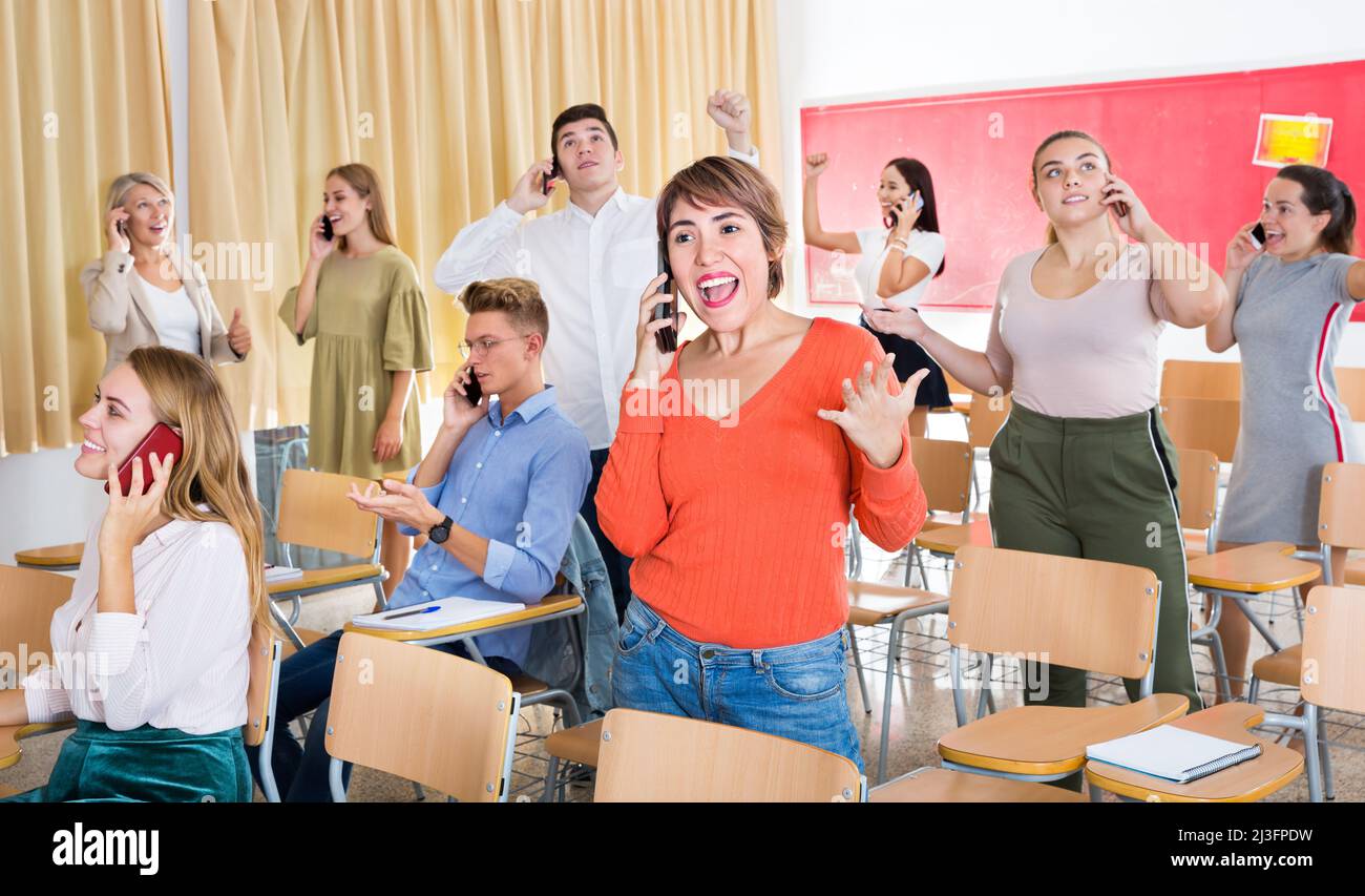 Student group talking on phones in classroom Stock Photo - Alamy