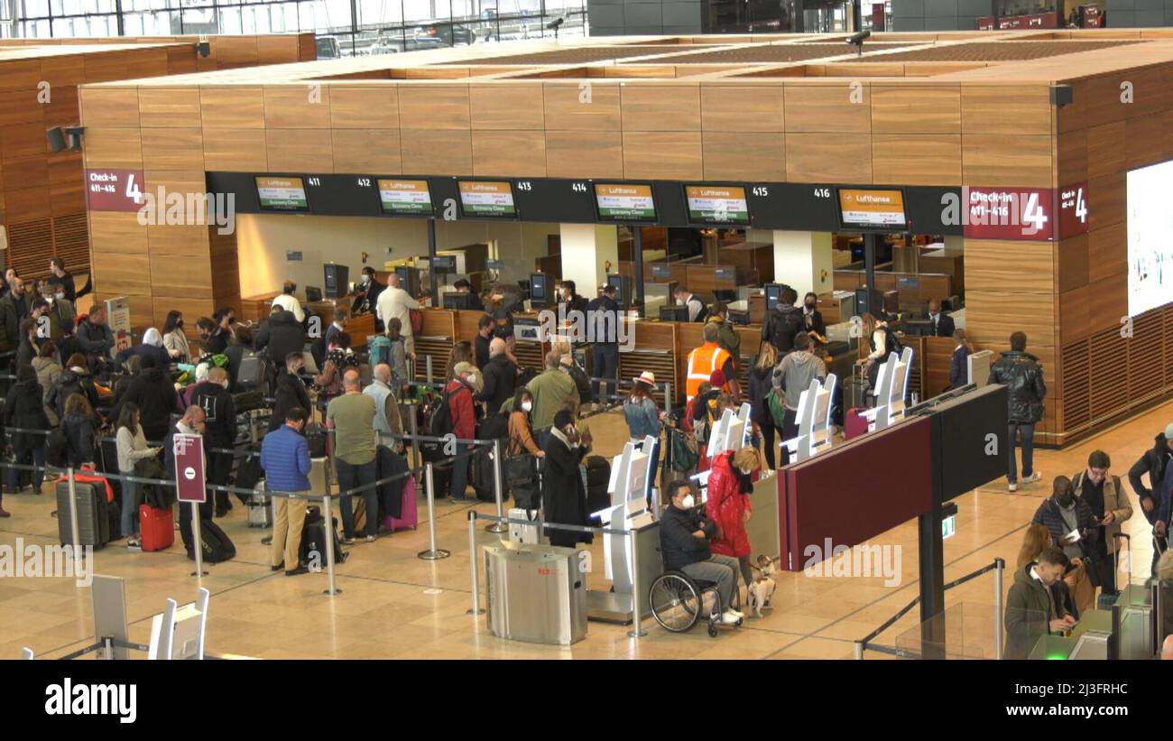 08 April 2022, Brandenburg, Schönefeld: Passengers waiting at the check ...