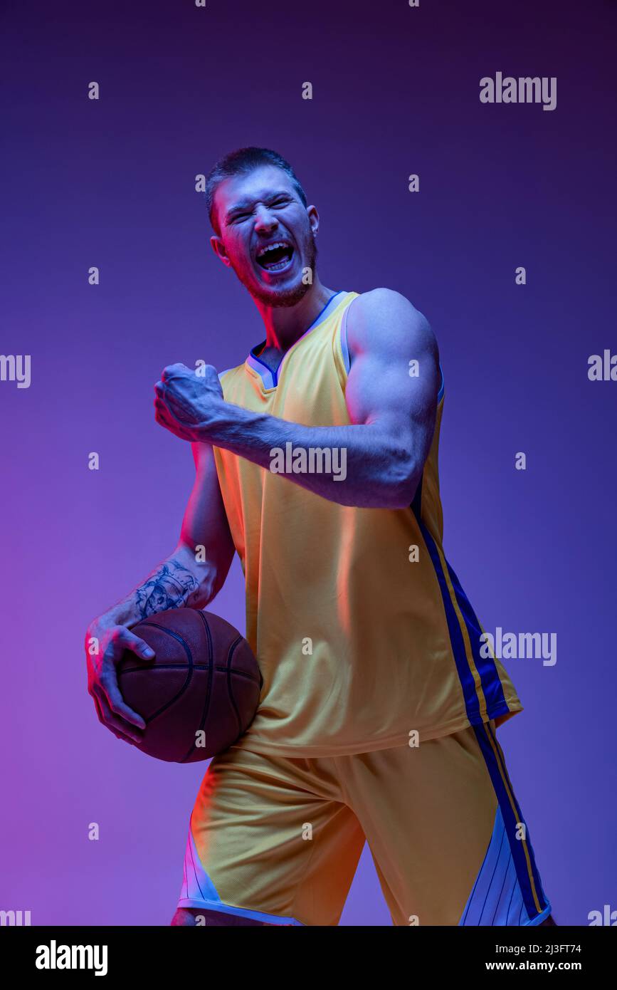 One excited man, basketball player shouting isolated on purple ...