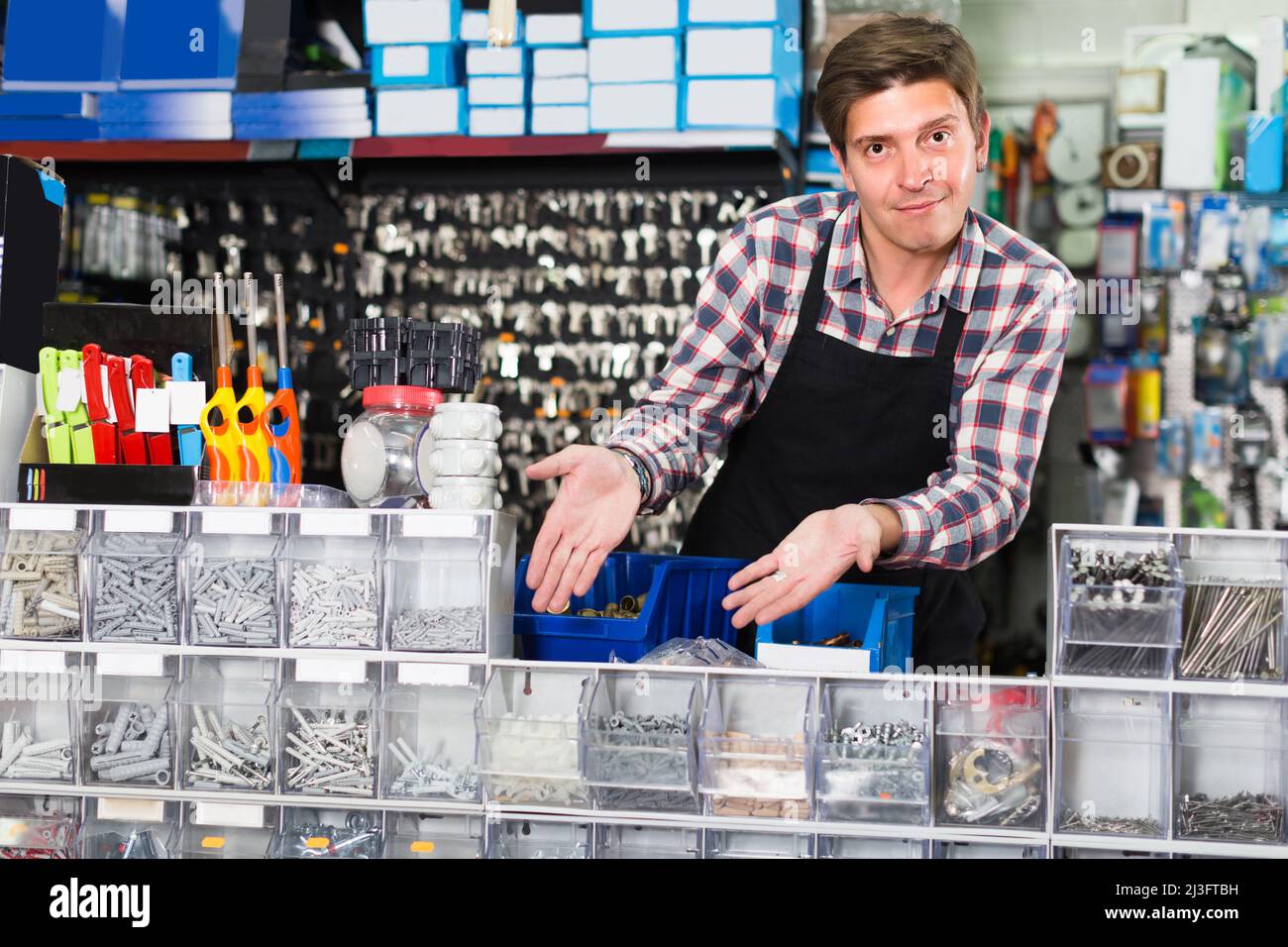 Smiling employee in hardware store is trading goods for construction ...