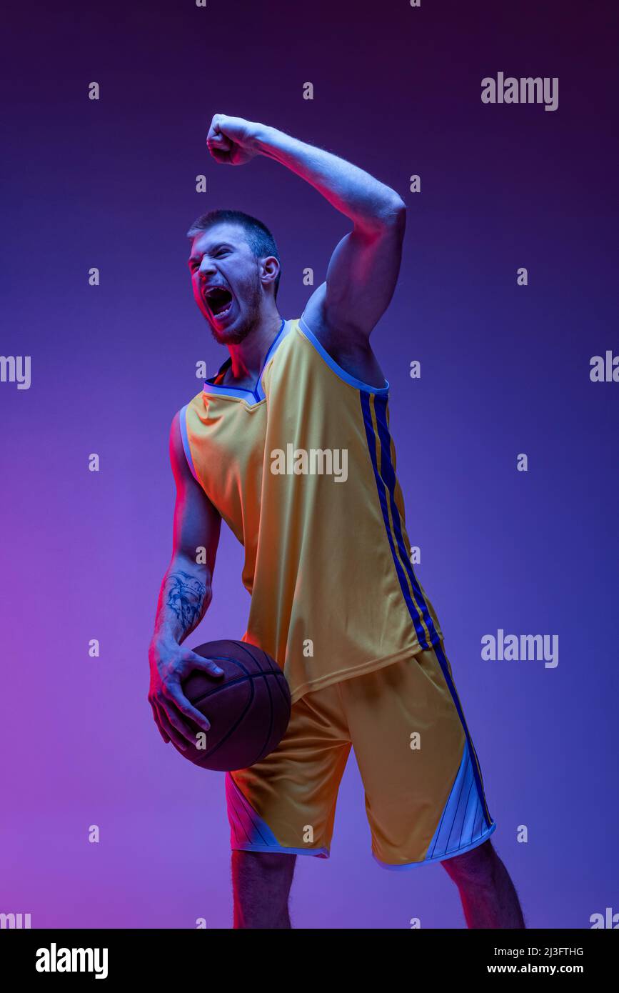 One excited man, basketball player shouting isolated on purple ...