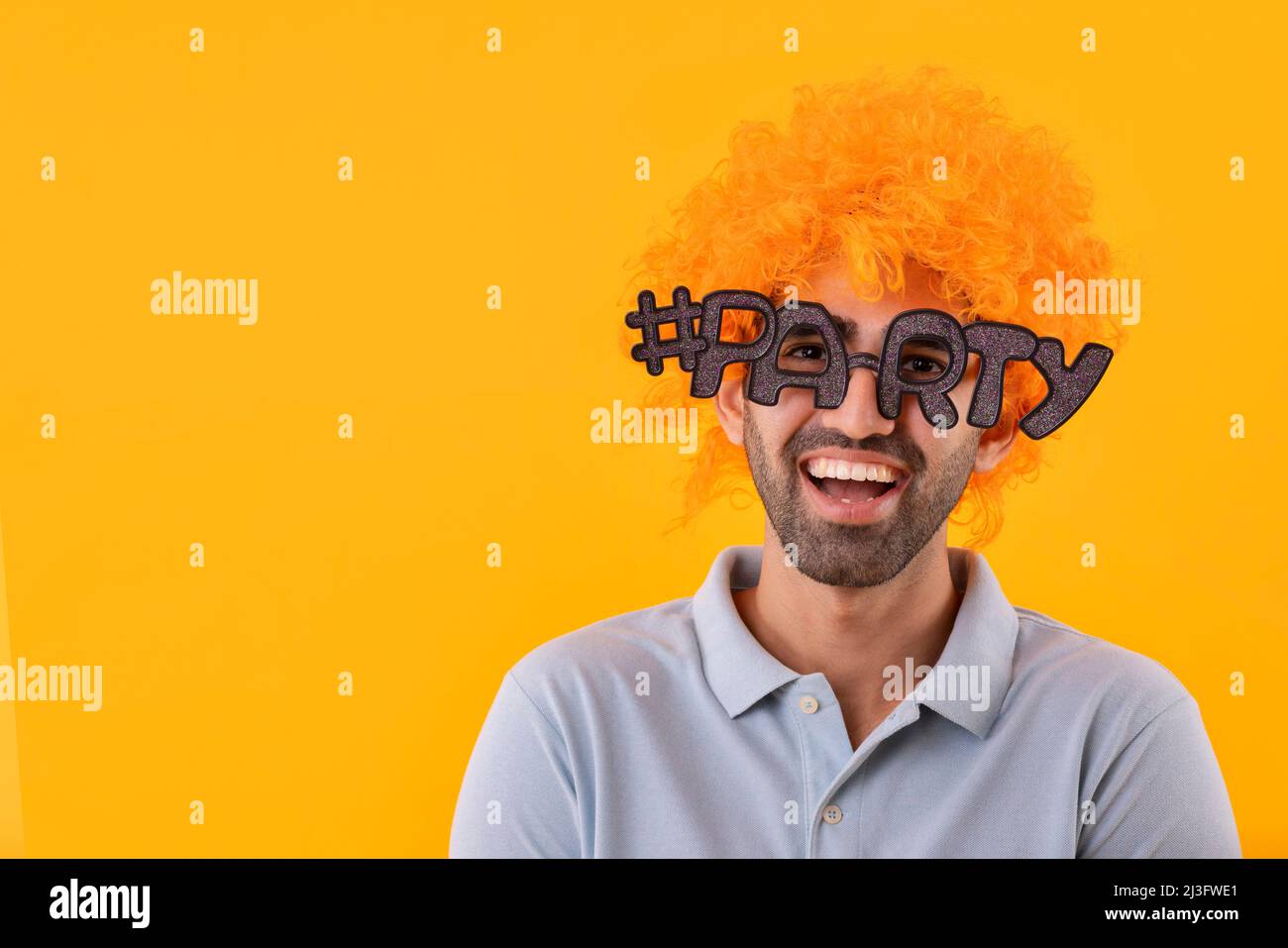 Crazy funny young man wearing party glasses with orange wig Stock Photo ...