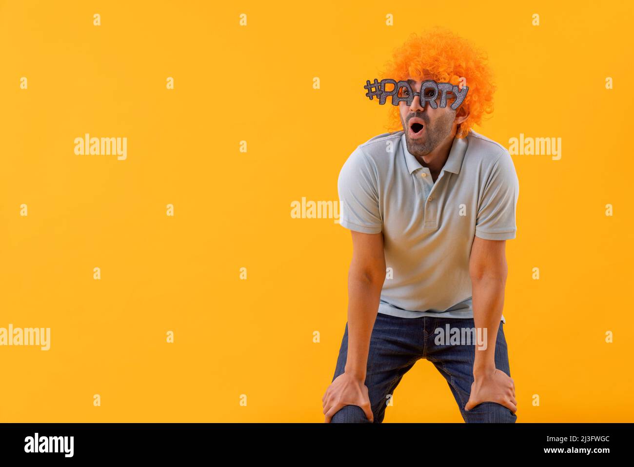 Crazy funny young man wearing party glasses with orange wig Stock Photo ...