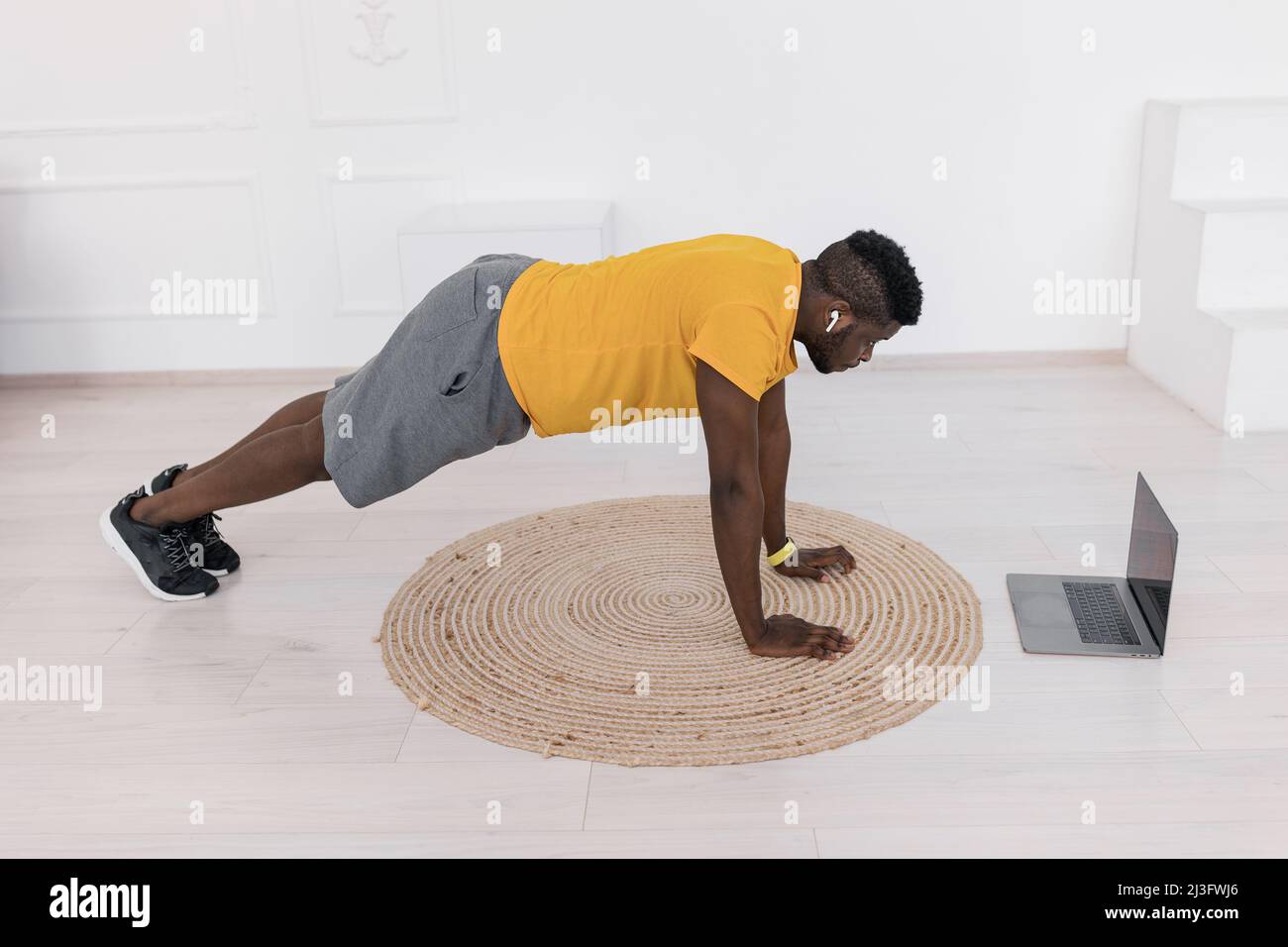 Sporty african american male stretching leg and back muscles in front ...