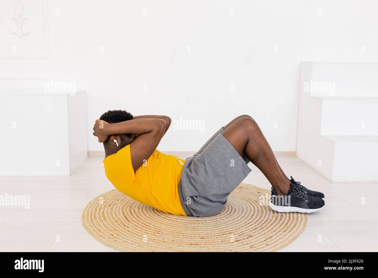 Sporty African American male doing home training and exercising doing ...