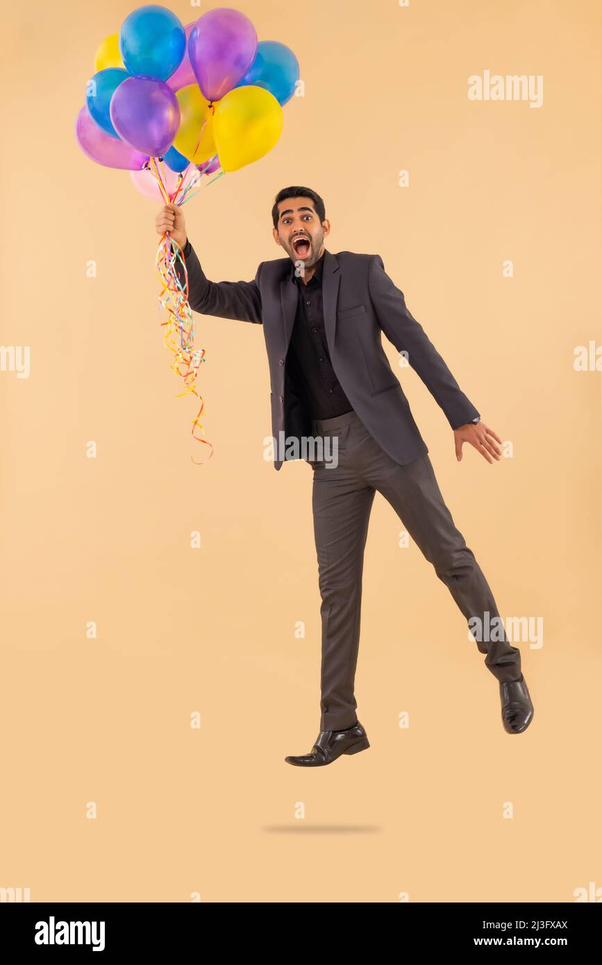 Happy businessman flying with air balloons Stock Photo - Alamy