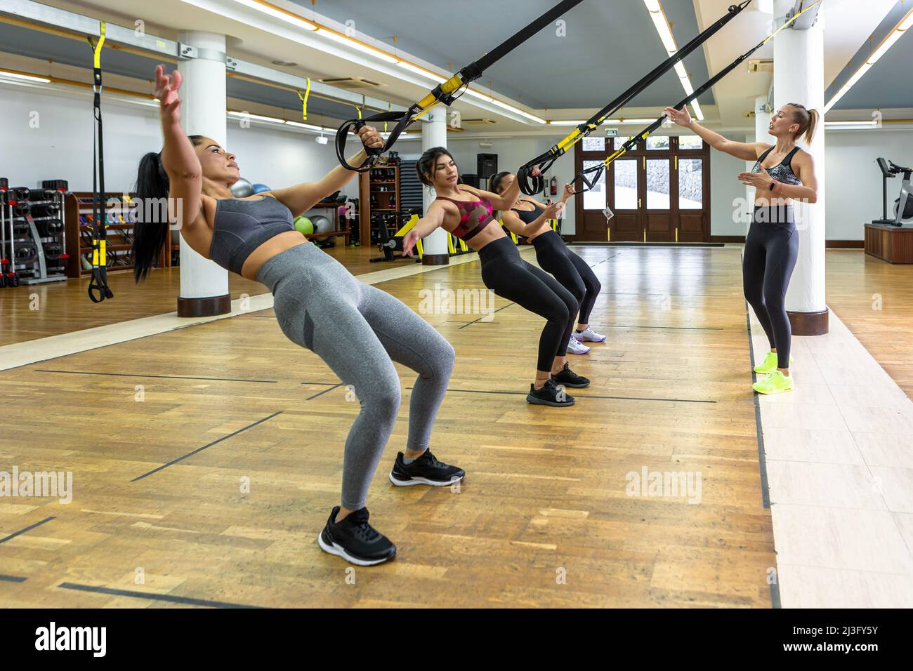 Female athletes tilting back and stretching out arms while exercising ...