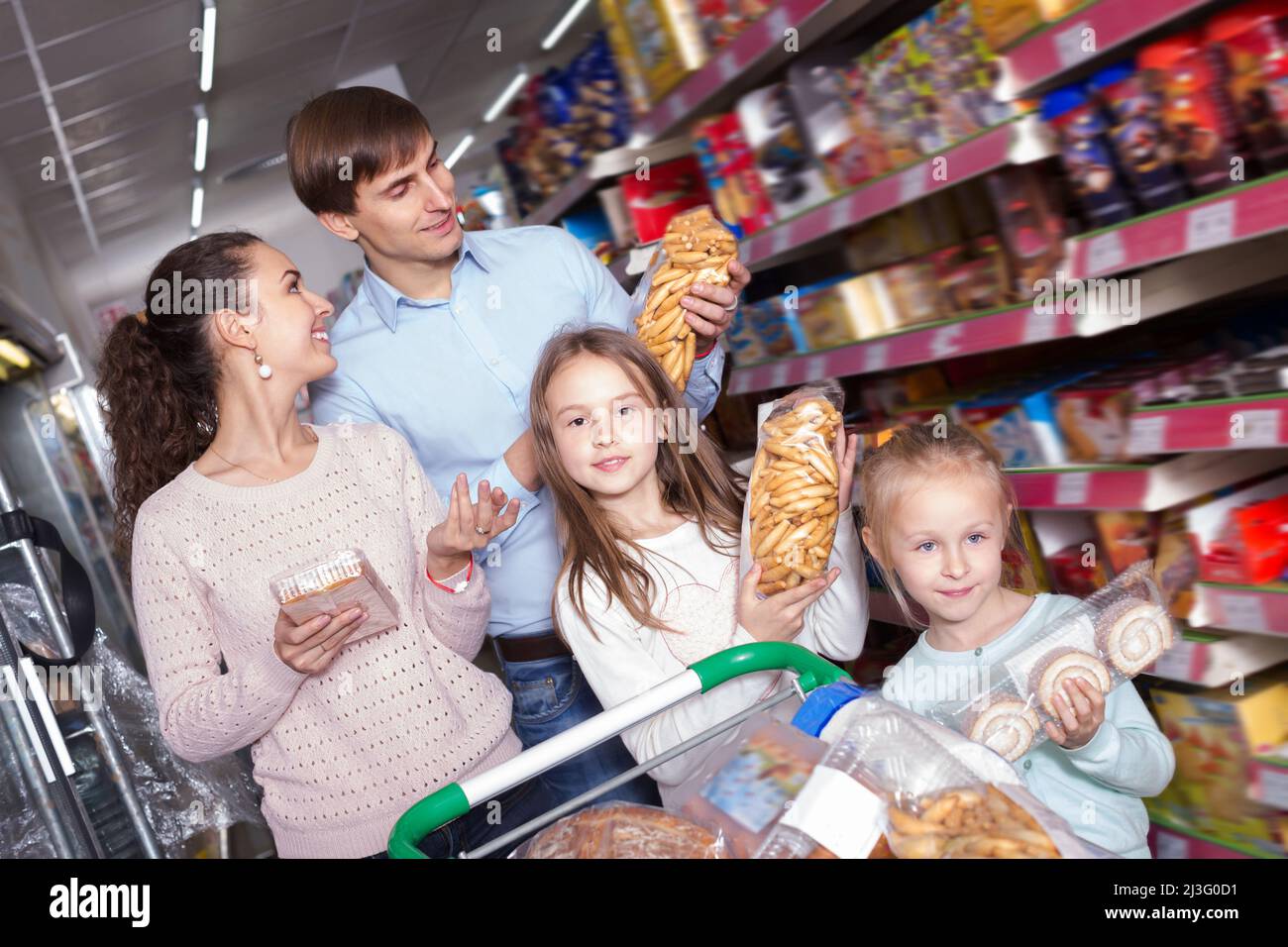 Happy family with little girls buying pastry Stock Photo - Alamy