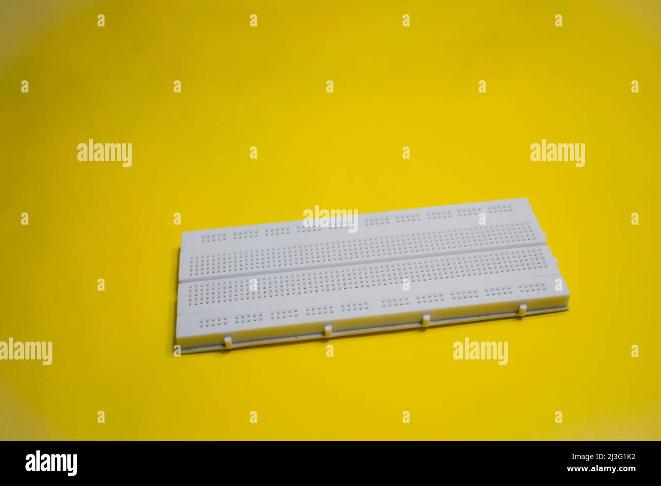 Electronic breadboard isolated on a yellow background Stock Photo - Alamy
