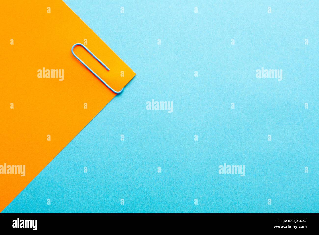 Minimalist background with blue paper clip on colorful background with ...